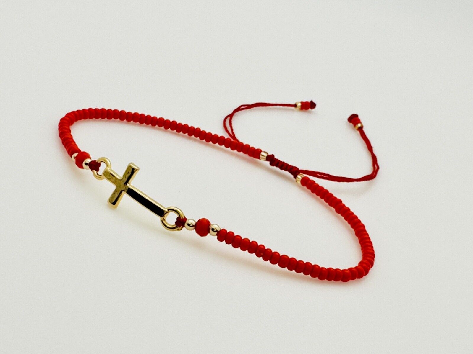 El significado de la pulsera roja con 10 nudos y una cruz